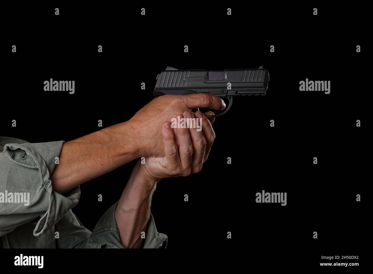 Male hands hold a handgun and aiming its to target. Isolated on black ...