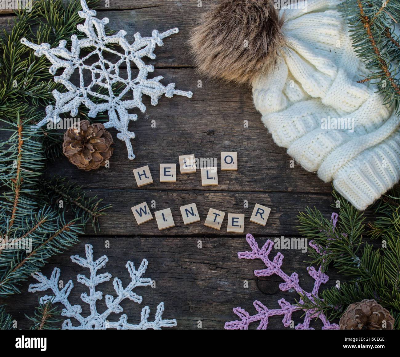 crochet snowflake ornaments on wooden ground with winter slogans and ...