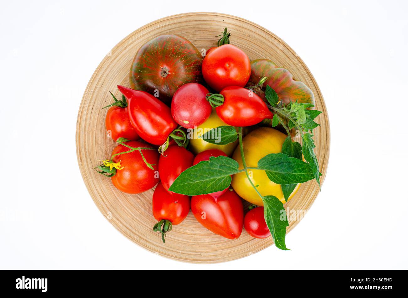 Assorted homemade colorful tomatoes different shapes on wooden plate ...