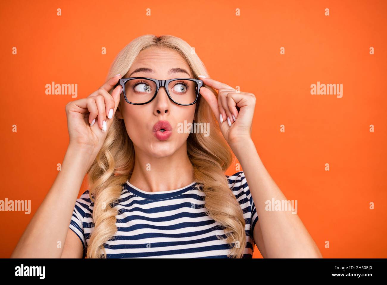Portrait Of Attractive Amazed Pretty Girl Touching Specs Looking Aside