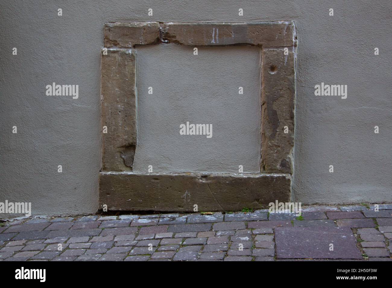 Ancient window frame made out of sandstone walled in a wall Stock Photo ...