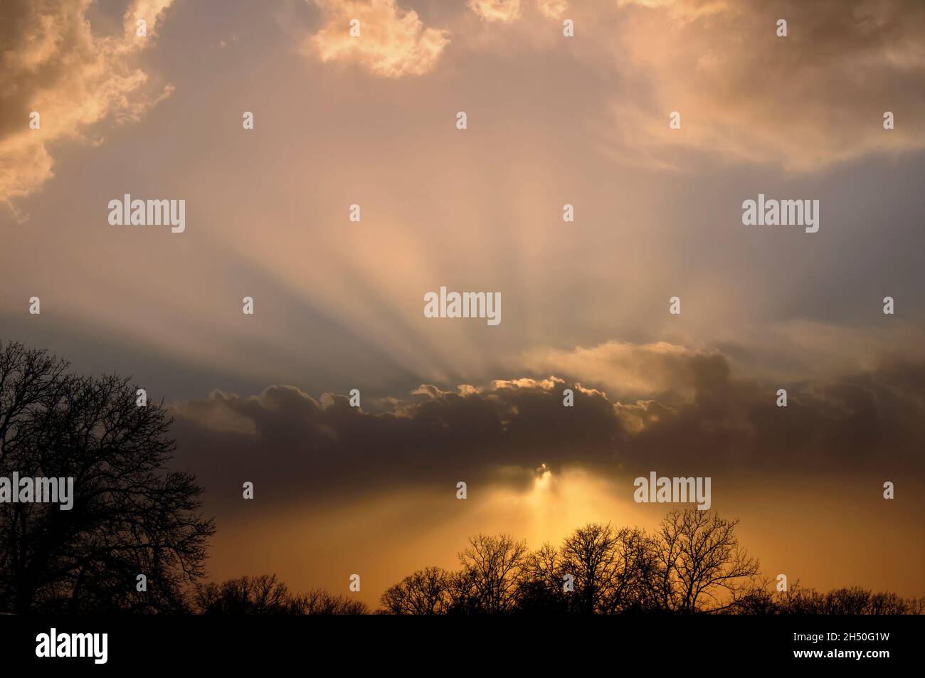 Dramatic storm clouds in the evening, with sun rays shining through the ...