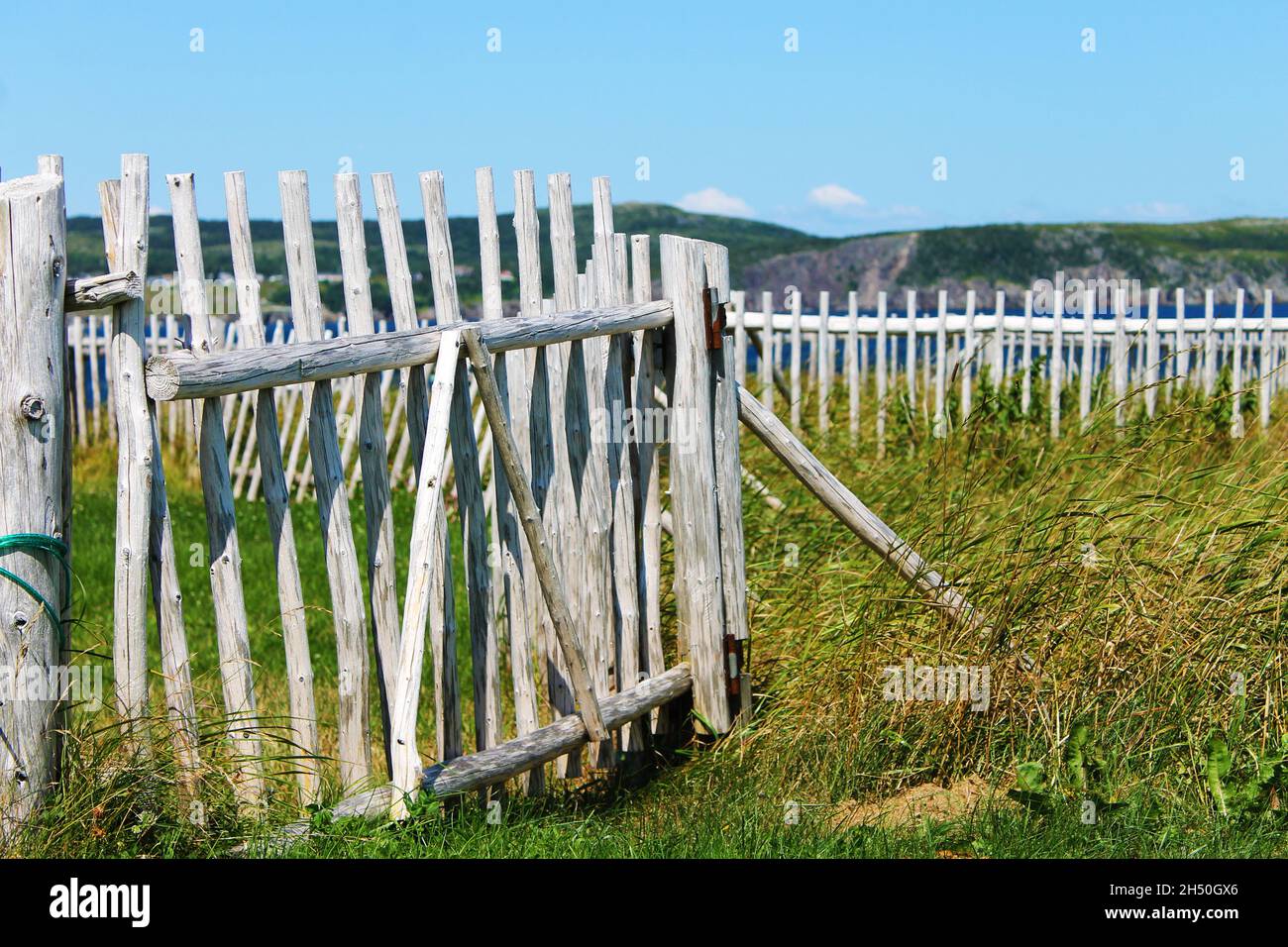 An open gate in an old, wooden fence made from sticks and logs Stock ...