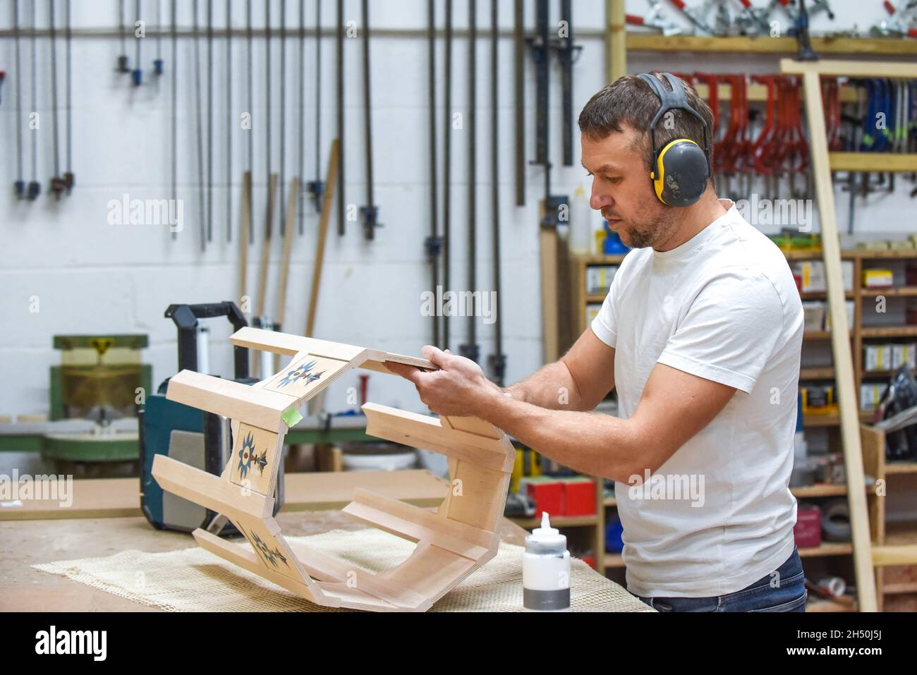 A man is making bespoke furniture in a woodwork workshop showing the ...