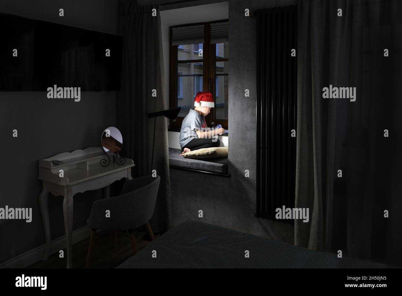 Boy wearing a santa claus hat writes a letter asking for a gift for ...