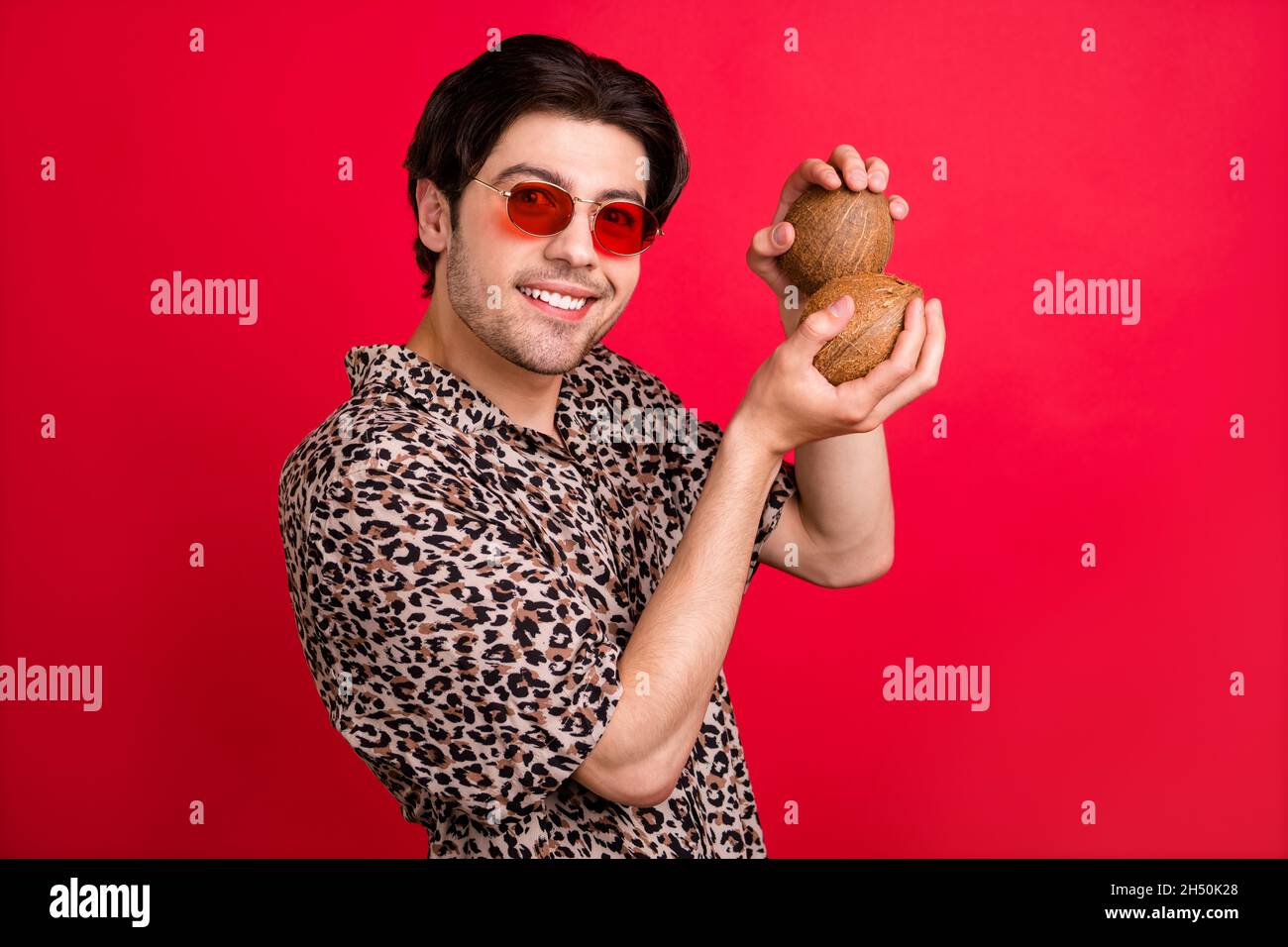 Photo of young handsome cheerful man in sunglass hold two coconut ...