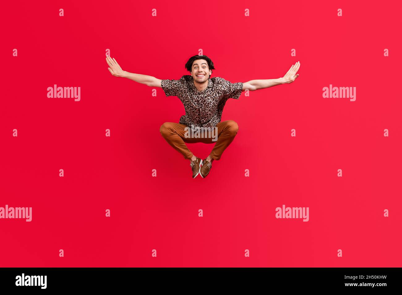 Full size photo of young smiling attractive guy jumping hands wings ...