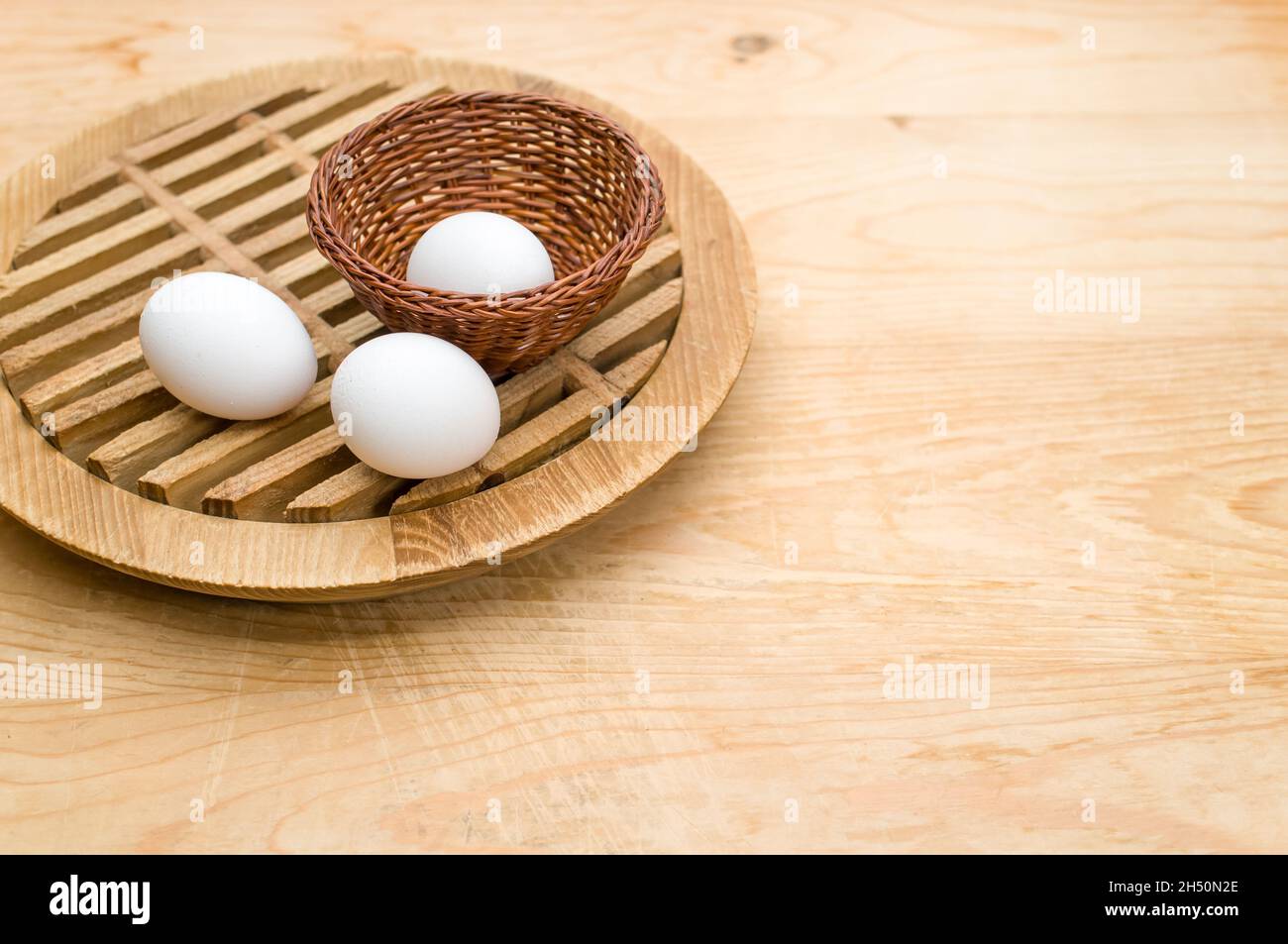 white eggs in a canister on a rustic wooden chopping board background ...