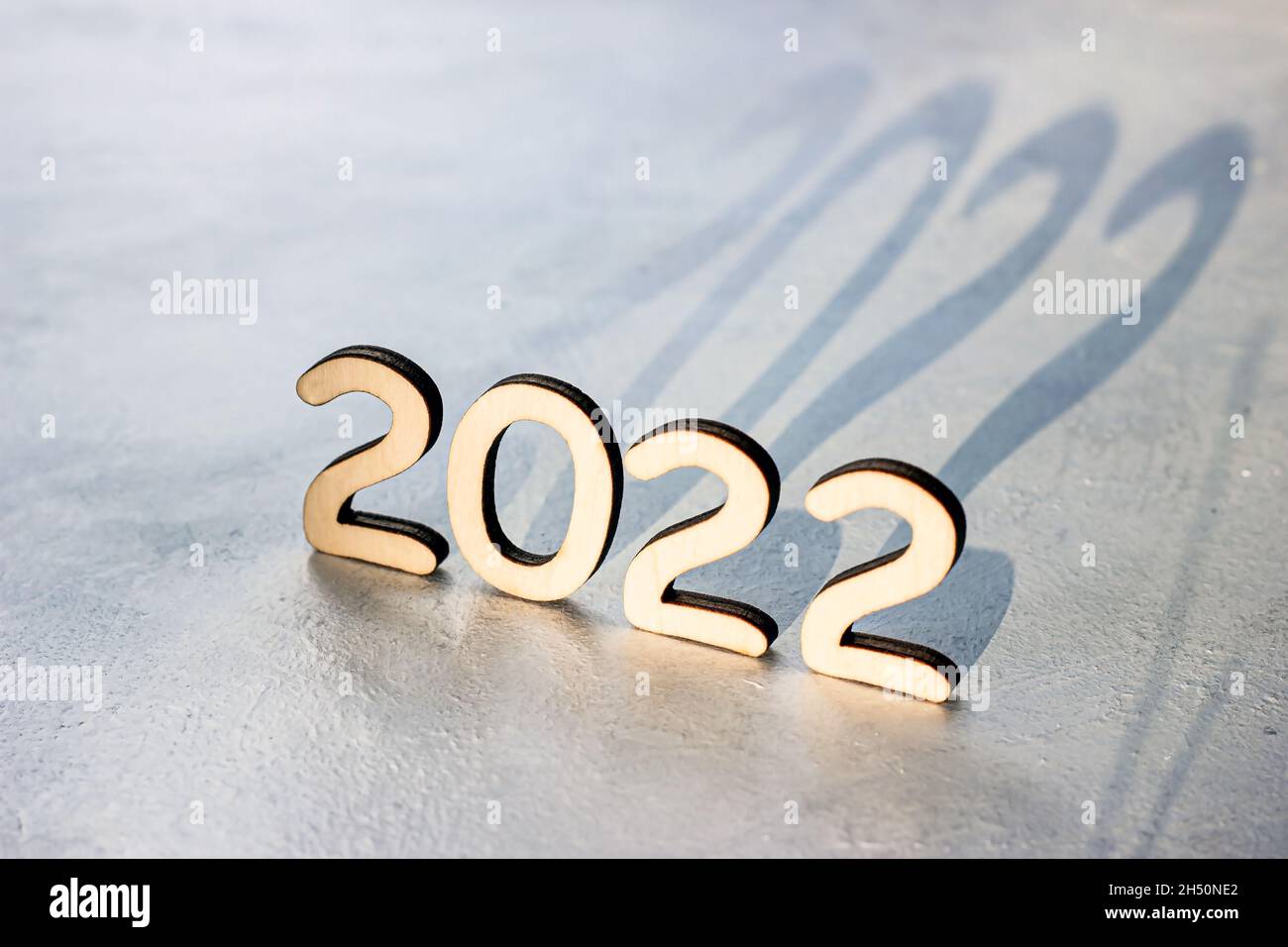 Wooden numbers 2022 silhouette with shadow on light background. New ...