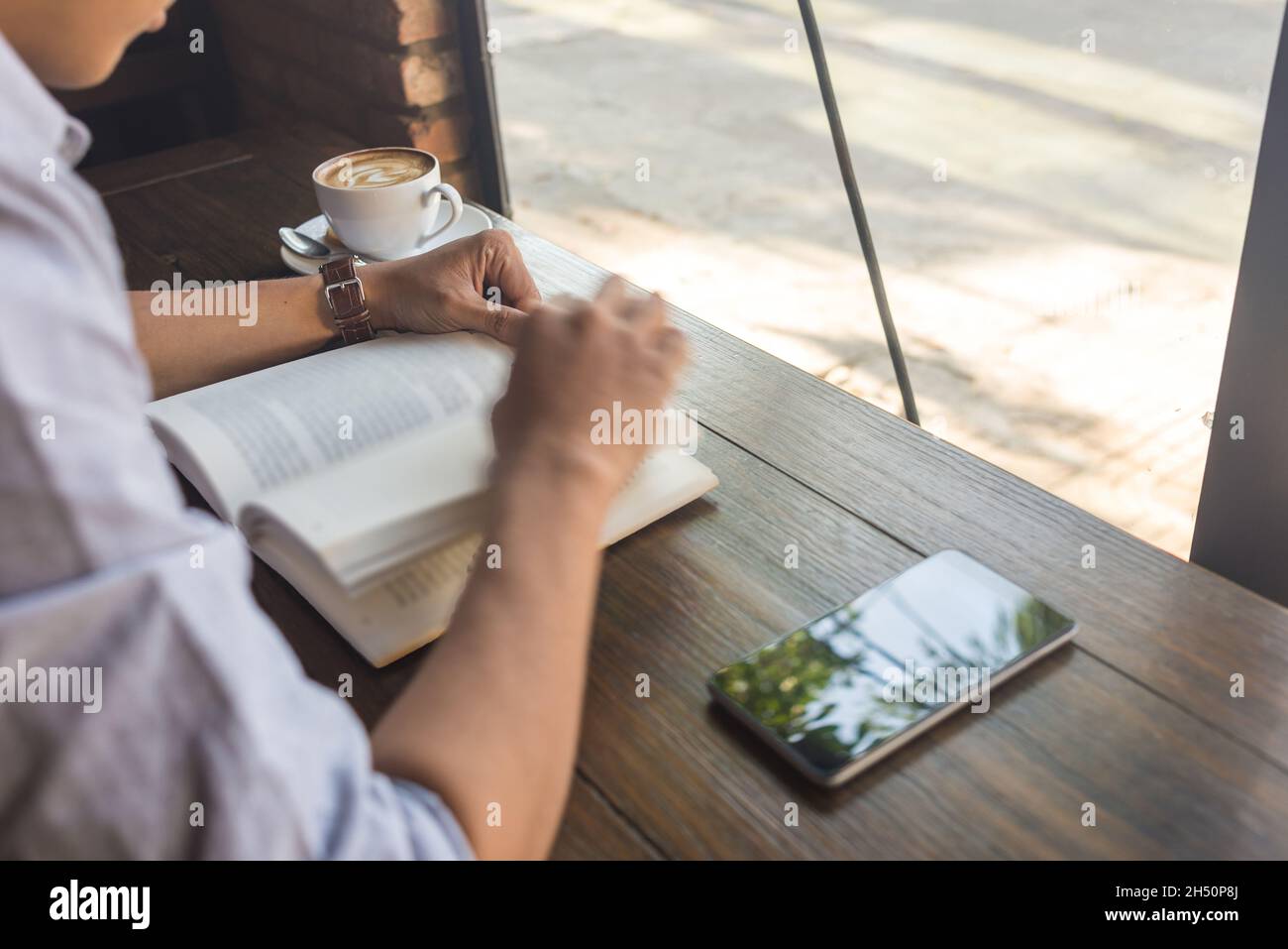 Man in white shirt reading favourite books Stock Photo - Alamy
