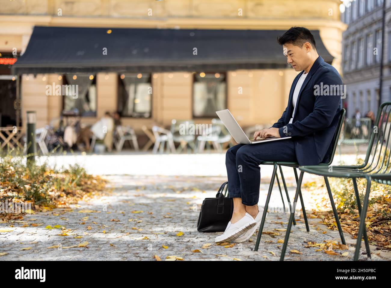 Businessman typing on laptop during work outdoors Stock Photo - Alamy