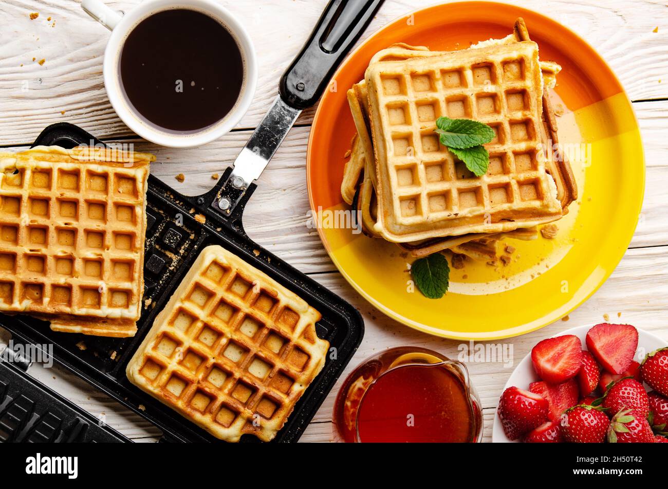 Flat lay view at Belgian waffles on cast skillet and stacked on plate ...