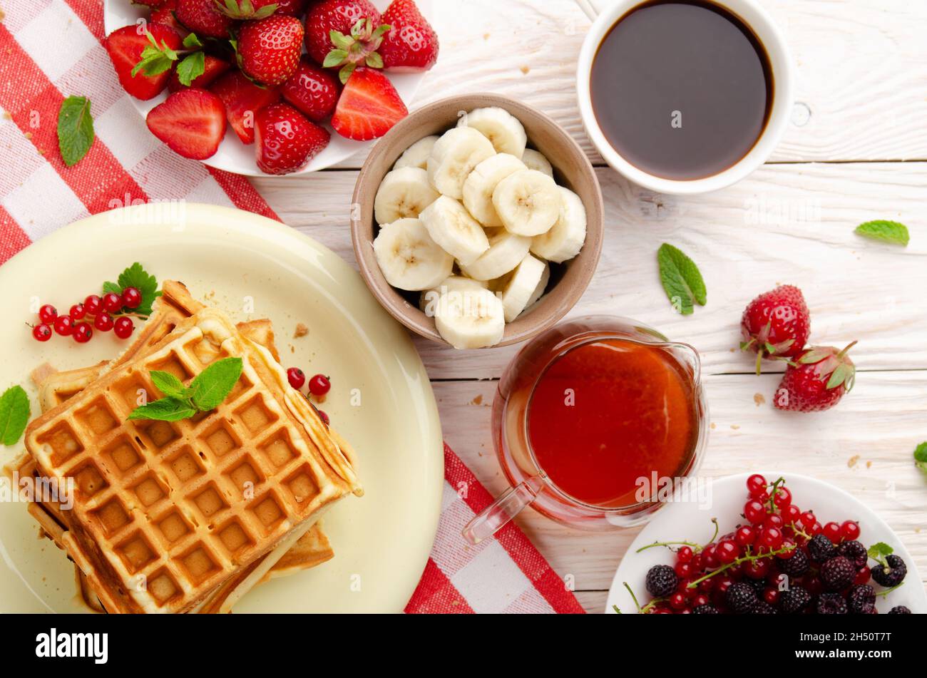 Flat lay view at three belgian waffles on white kitchen table with ...