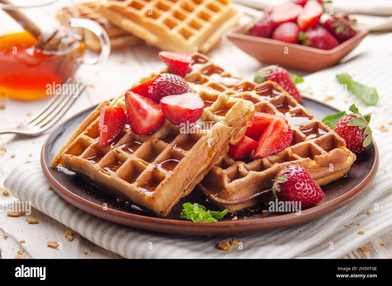 Homemade crispy Belgian waffles served with strawberries and honey ...