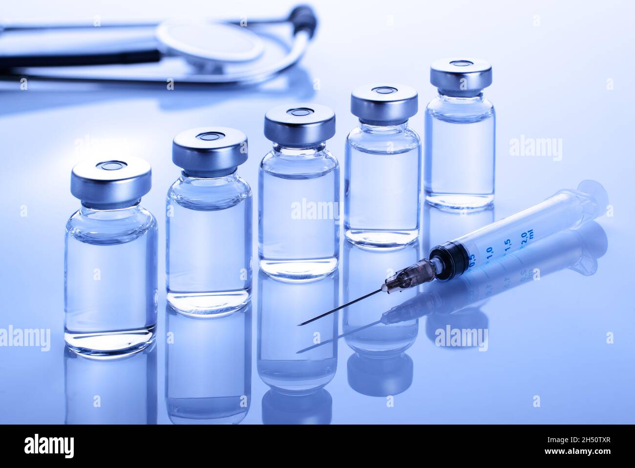 Vials with liquid drug as vaccine dose flu shot along with stethoscope ...