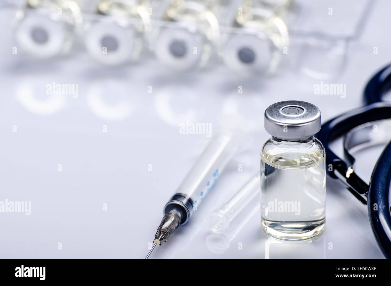 Vial with liquid drug as vaccine dose flu shot along with stethoscope ...