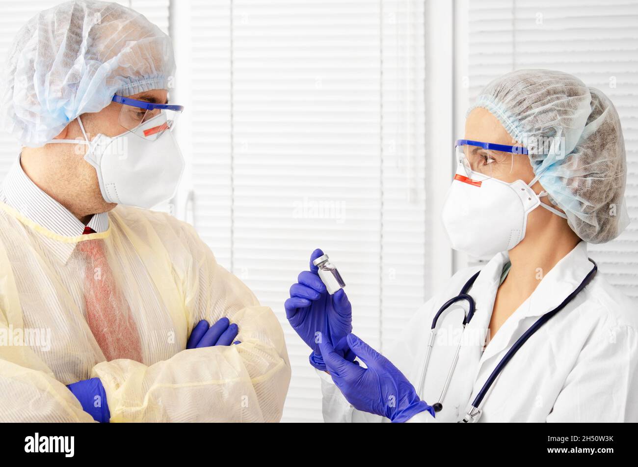 Male and female health care workers in masks caps and gloves having ...