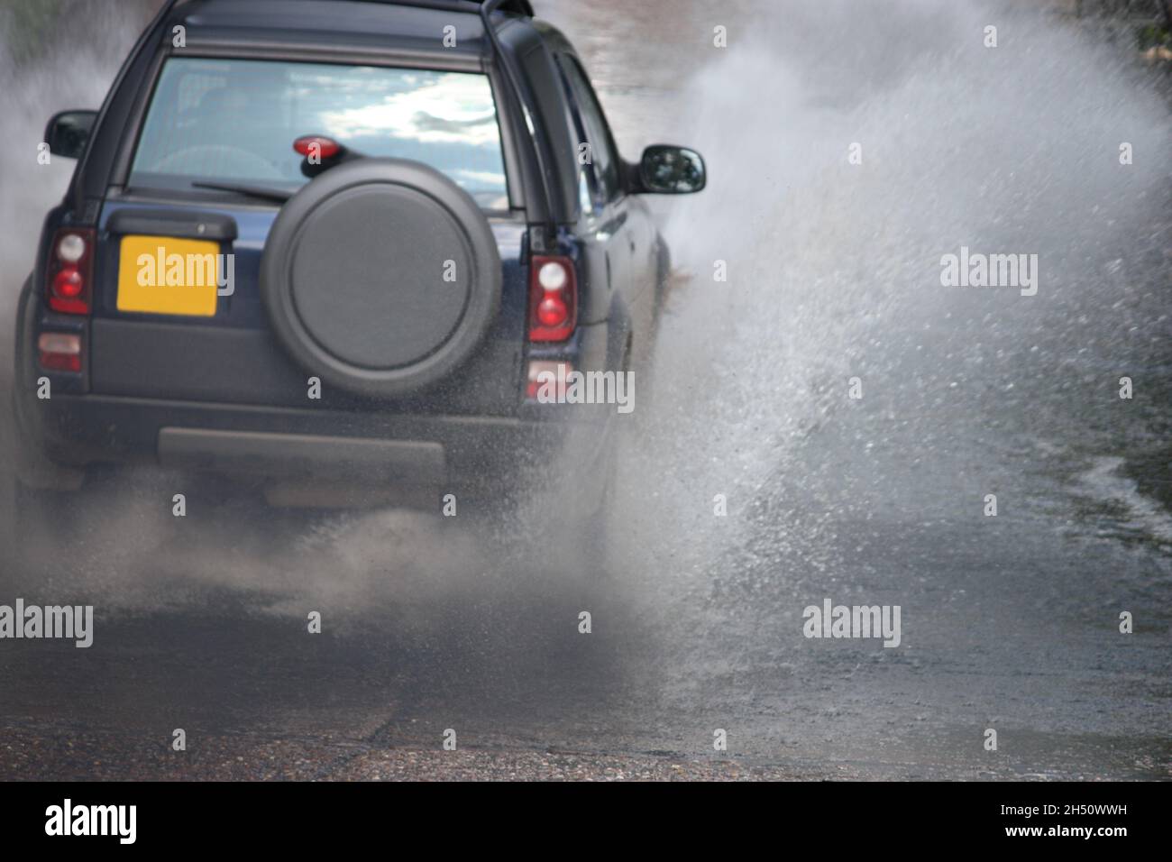 A Car Driving Through a Water Flood Stock Photo - Alamy