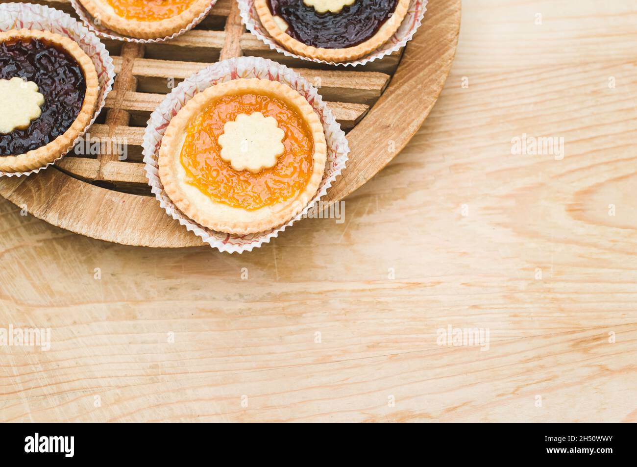 apricot and cherry jam short crust pastry in a paper backing cup on a ...