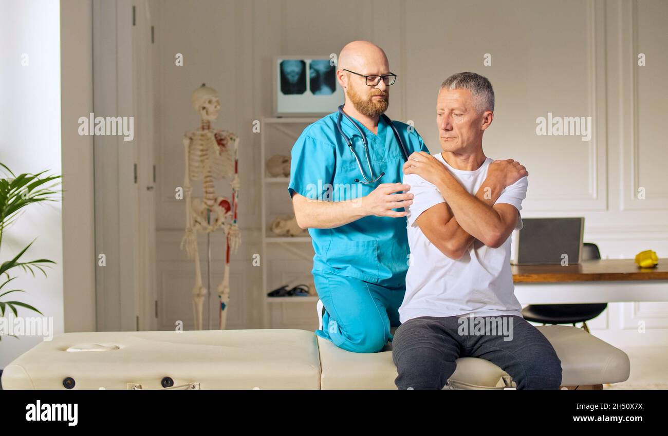 An Adult Man Trains Muscle Strength With a Professional Doctor in a ...