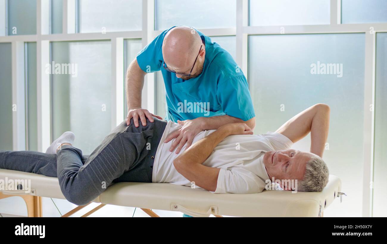 An Adult Man Trains Muscle Strength With a Professional Doctor in a ...