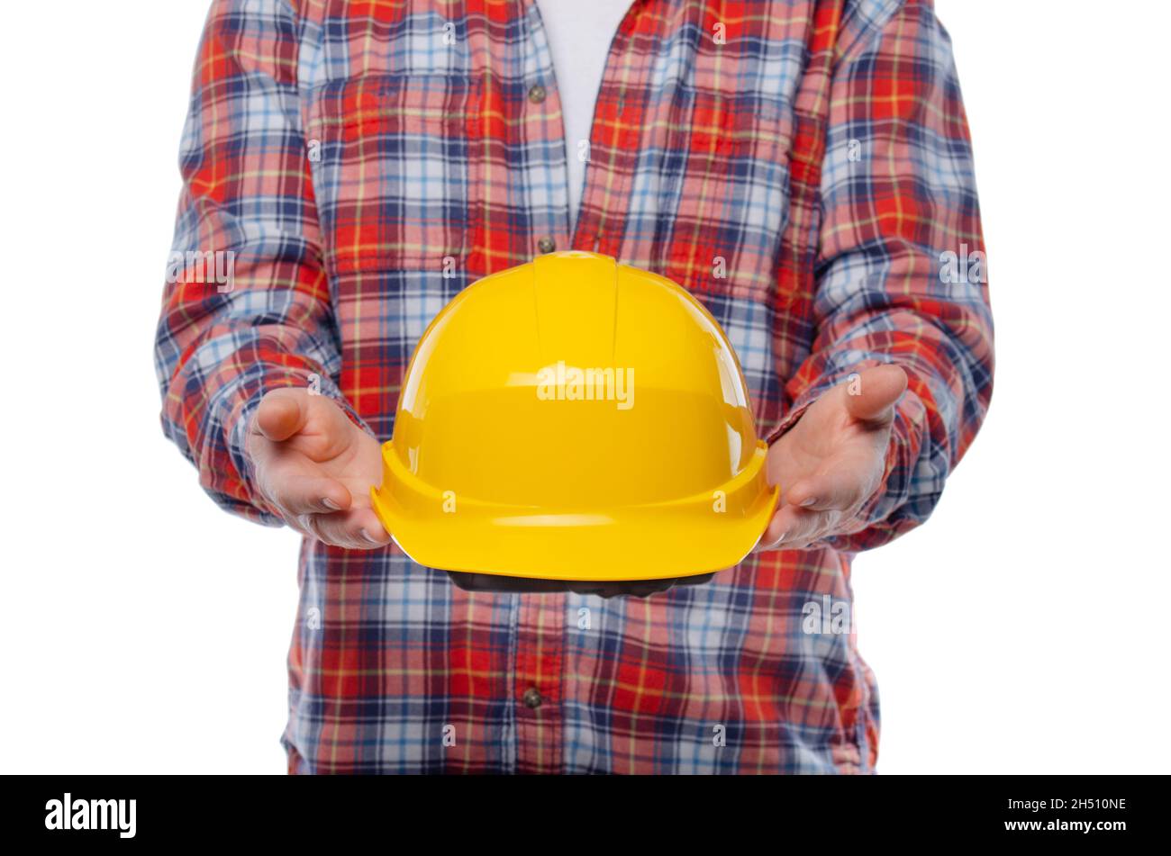 Caucasian laborer offers yellow hard hat in his hands on white ...