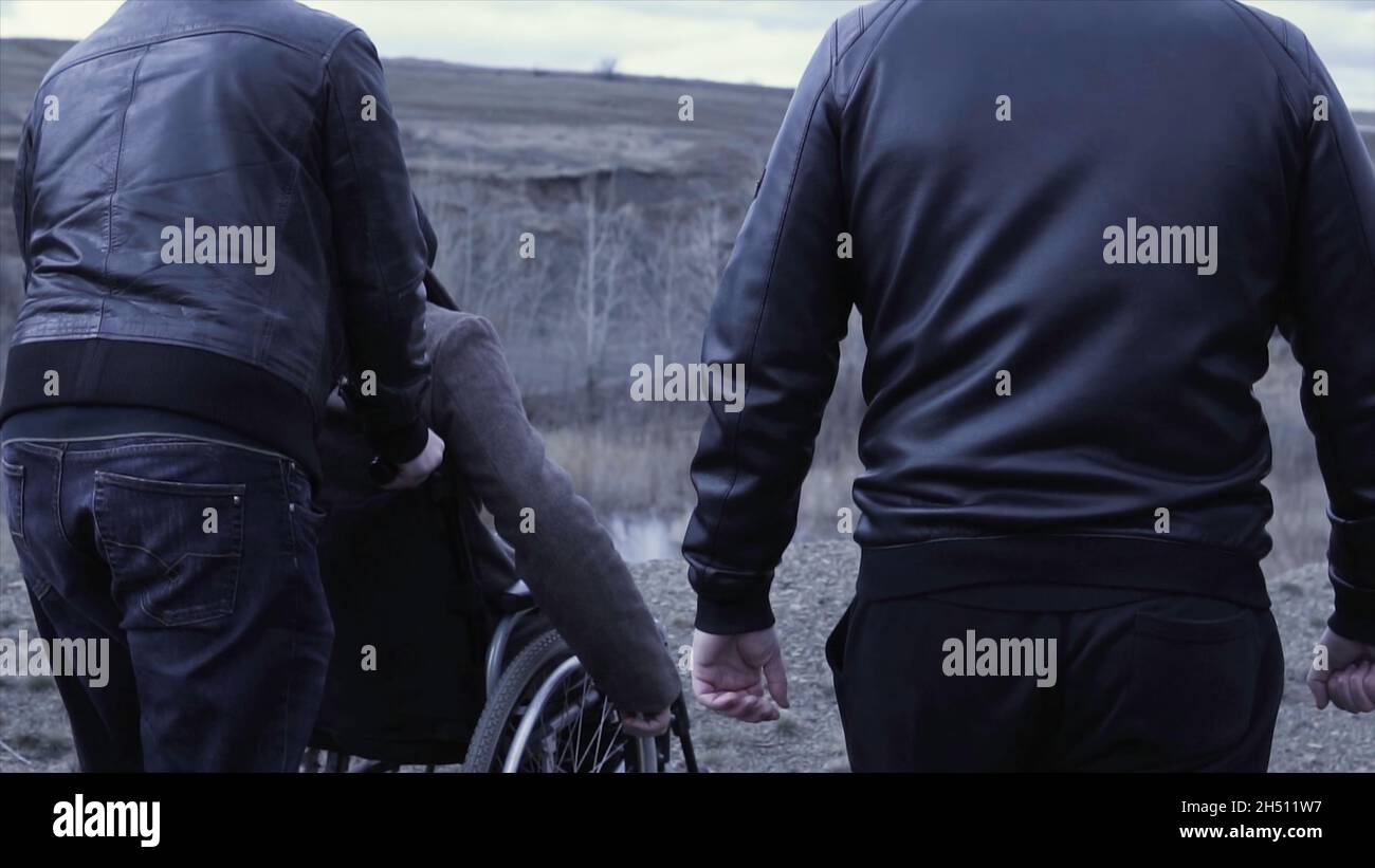 Gang of men in black jackets. Footage. Rear view of gang of gangsters ...