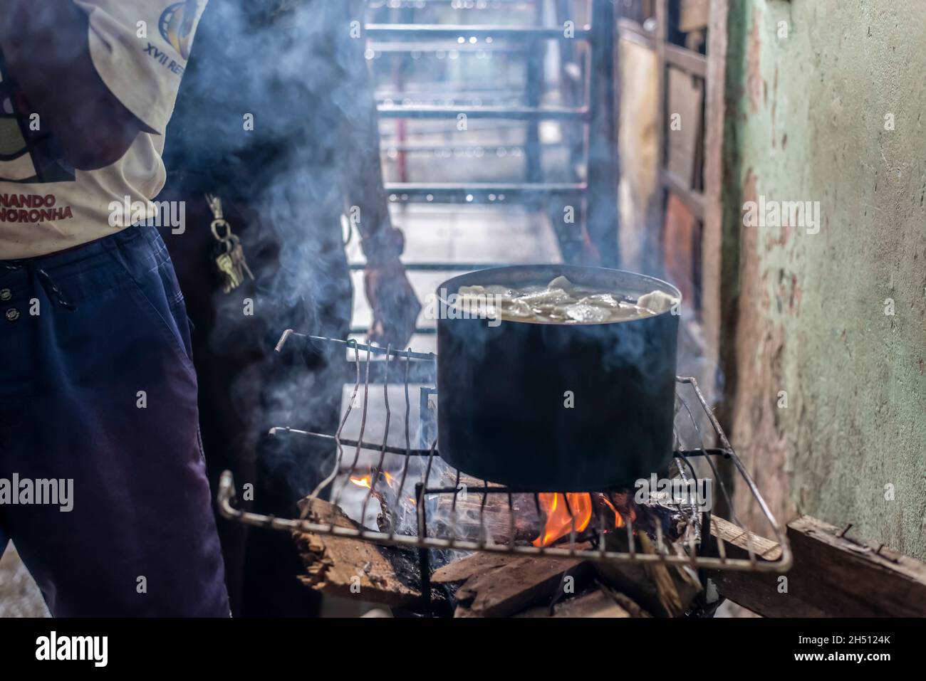 Men cooking cassava in an iron pot with a wood fire at the São Joaquim ...