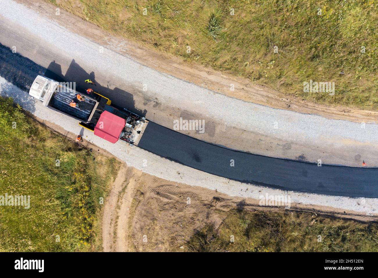 Aerial view of new road construction with asphalt laying machinery at ...