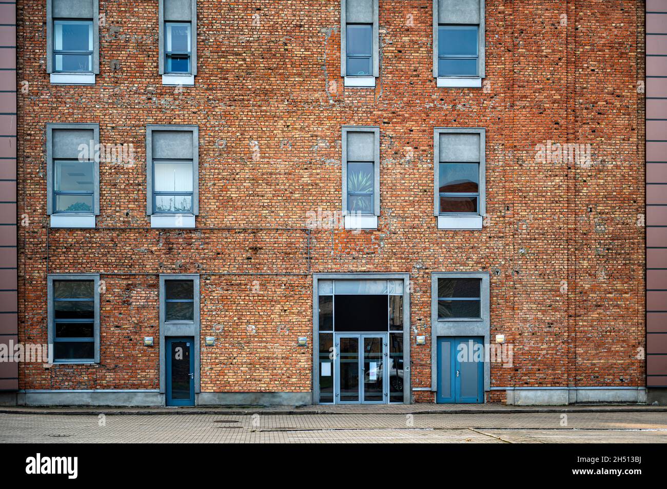 renovated red brick house facade with modern windows and glass doors ...