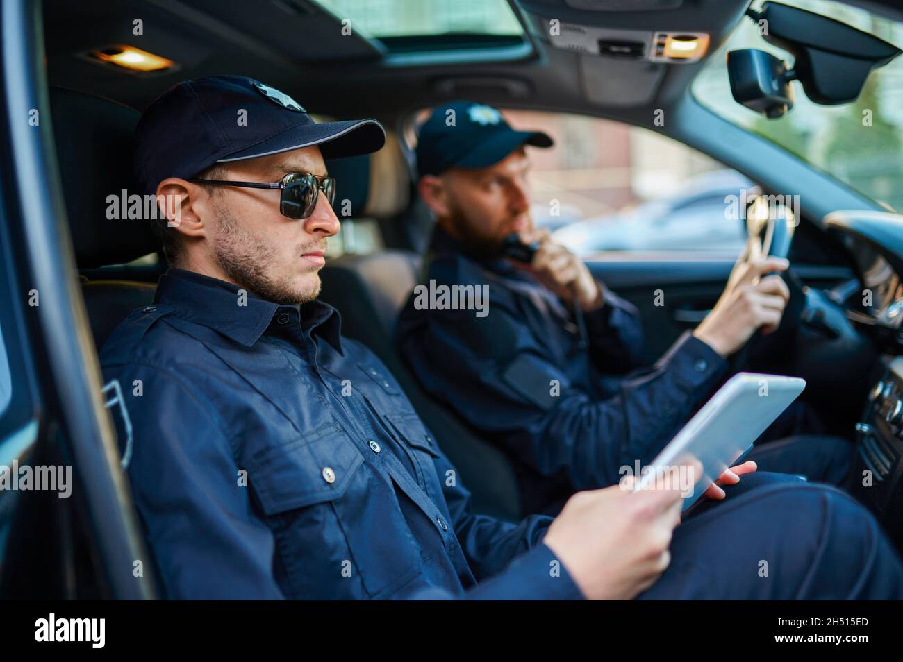 Two male police officers in uniform poses in car Stock Photo - Alamy
