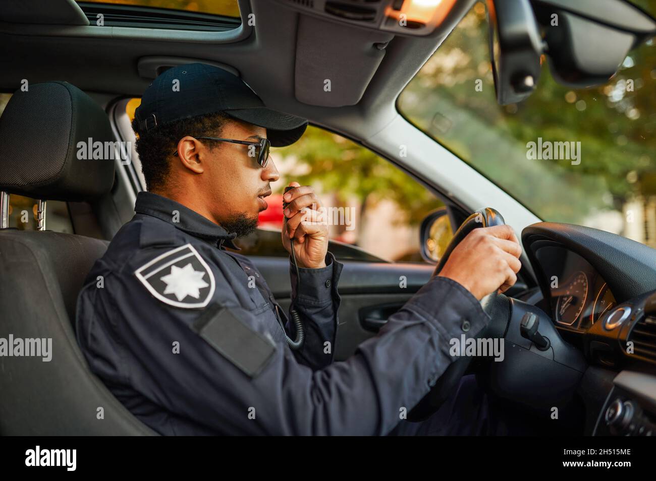 Male police officer talking on a walkie-talkie Stock Photo - Alamy