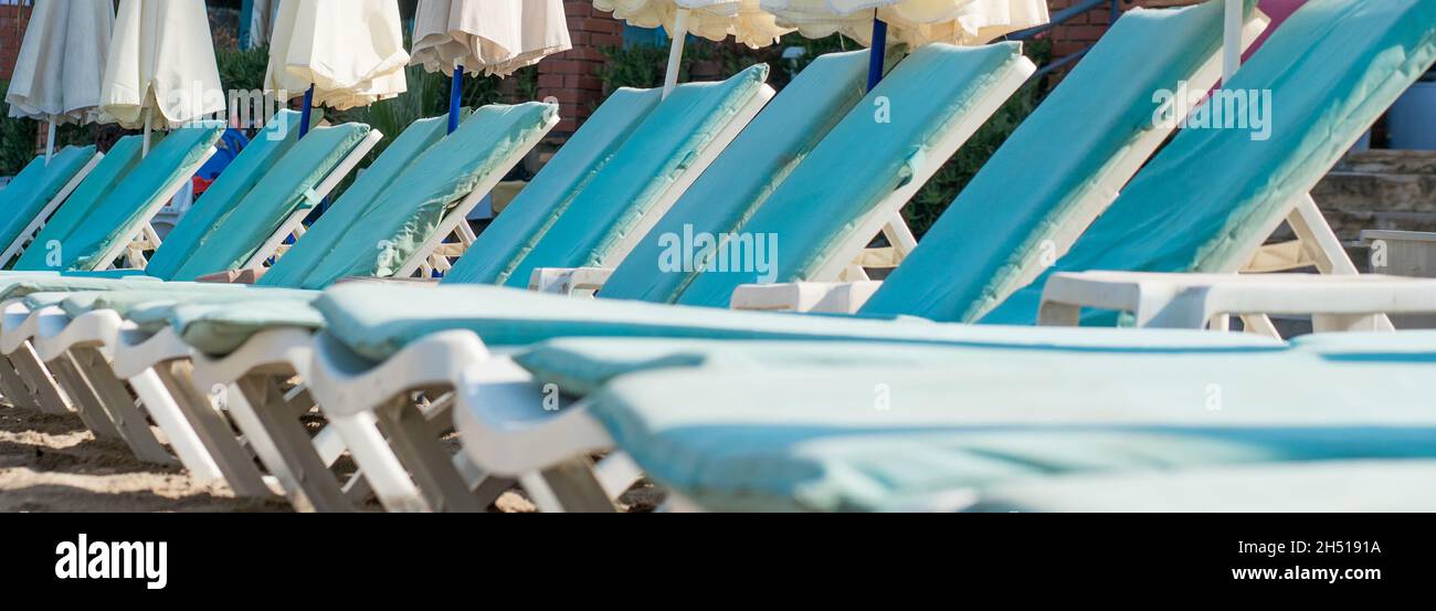 Empty blue sunbeds on a modern beach Stock Photo - Alamy