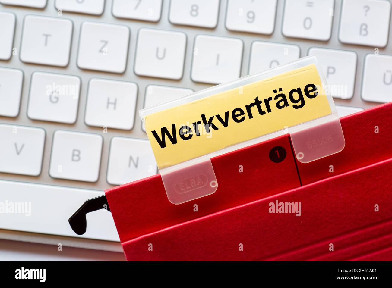 the German word work contracts on the tab of a red hanging folder. A ...