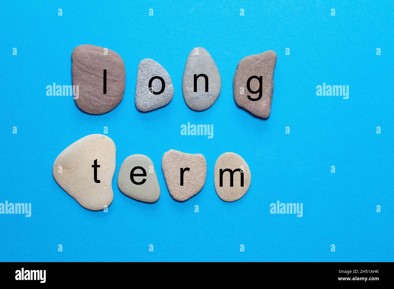 The word long term is written on polished natural stones that are true ...