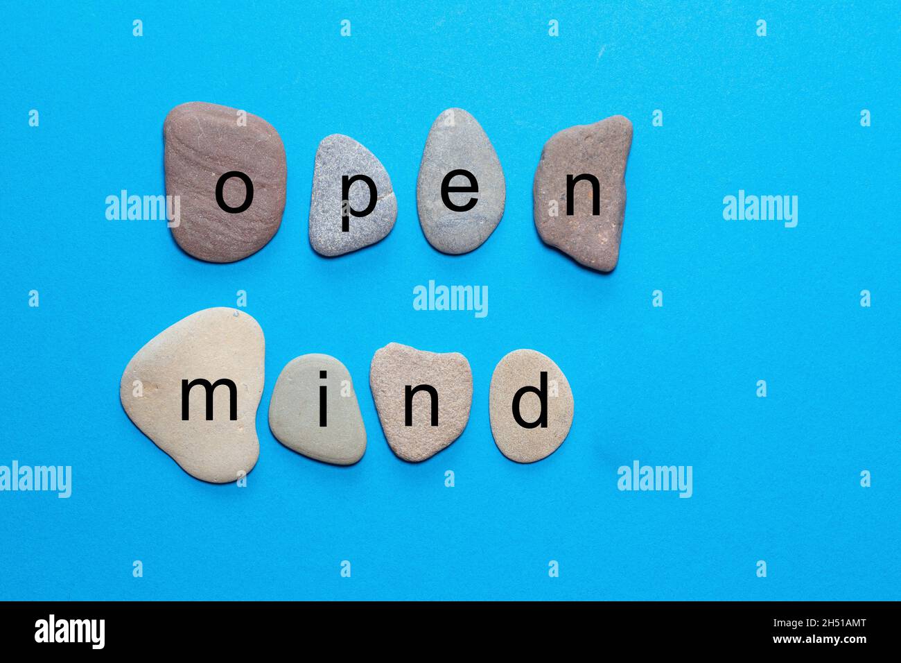 The word open mind is written on polished natural stones that are true ...