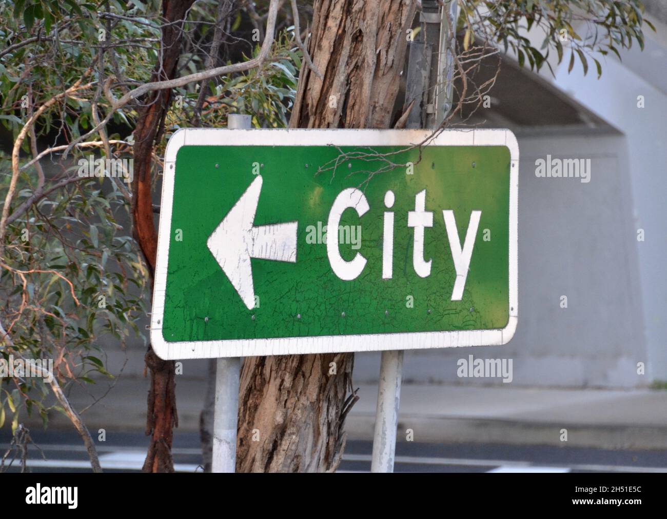 Green and white directional information road sign with an arrow ...