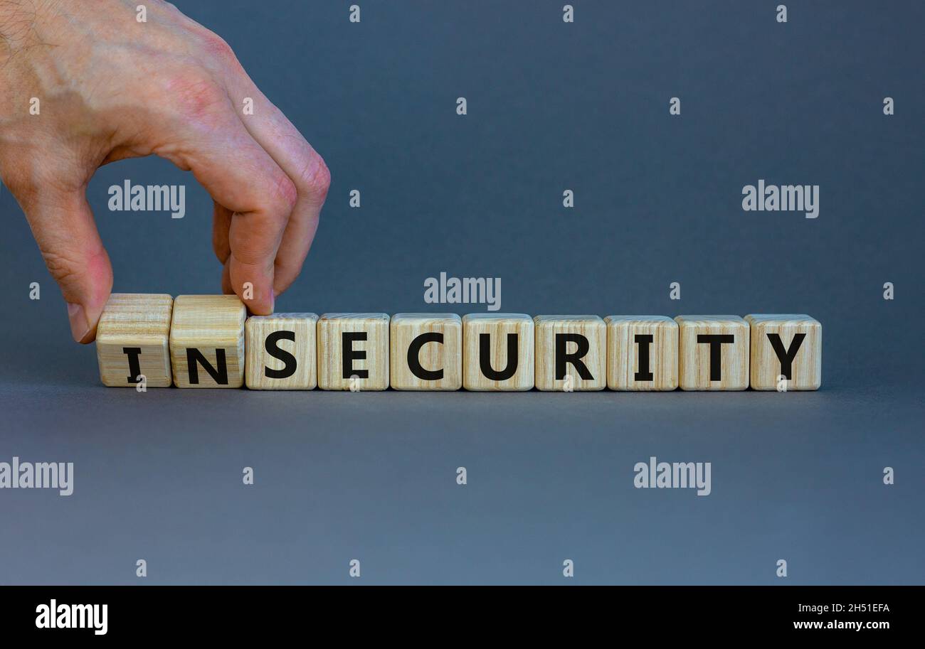 Security or insecurity symbol. Businessman turns wooden cubes, changes ...