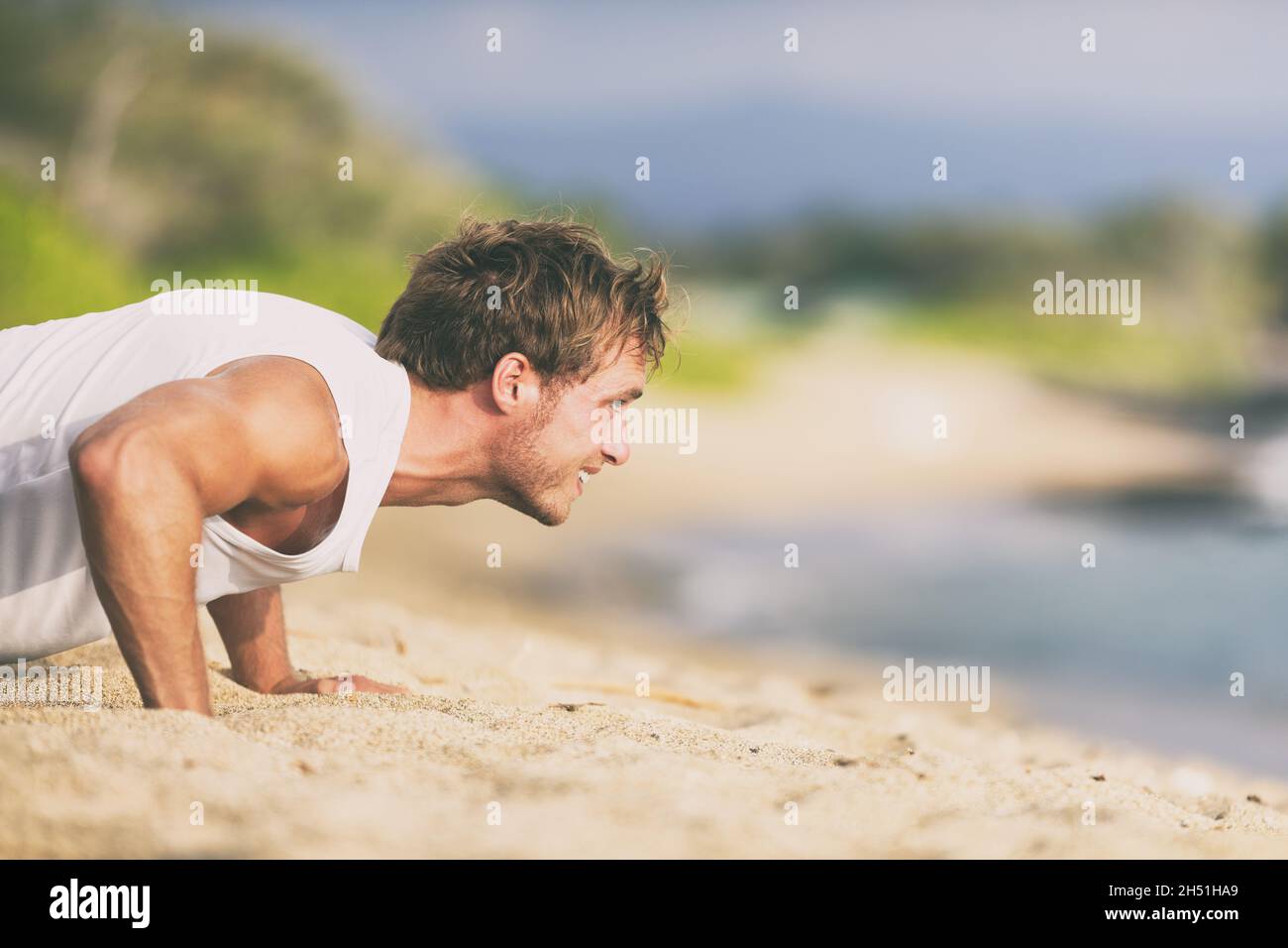 Fit man training on beach doing push-ups workout summer fitness ...