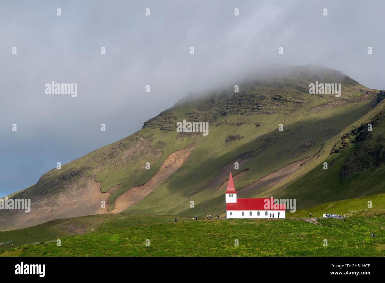 Landscape of Vik i Myrdal church on hill with grassy cliffs in Vik ...