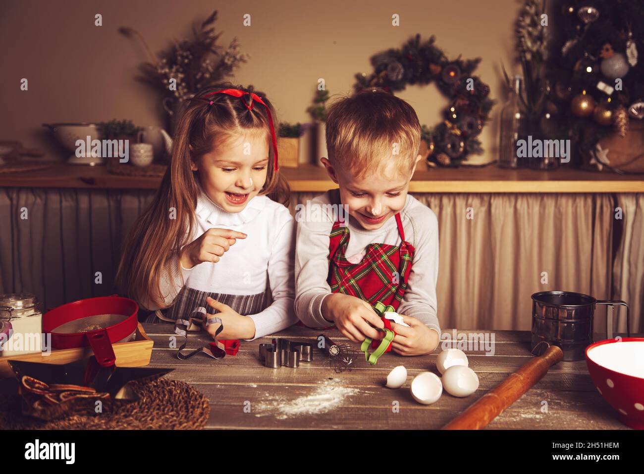 Children in the kitchen are preparing cookies. Christmas decorations ...