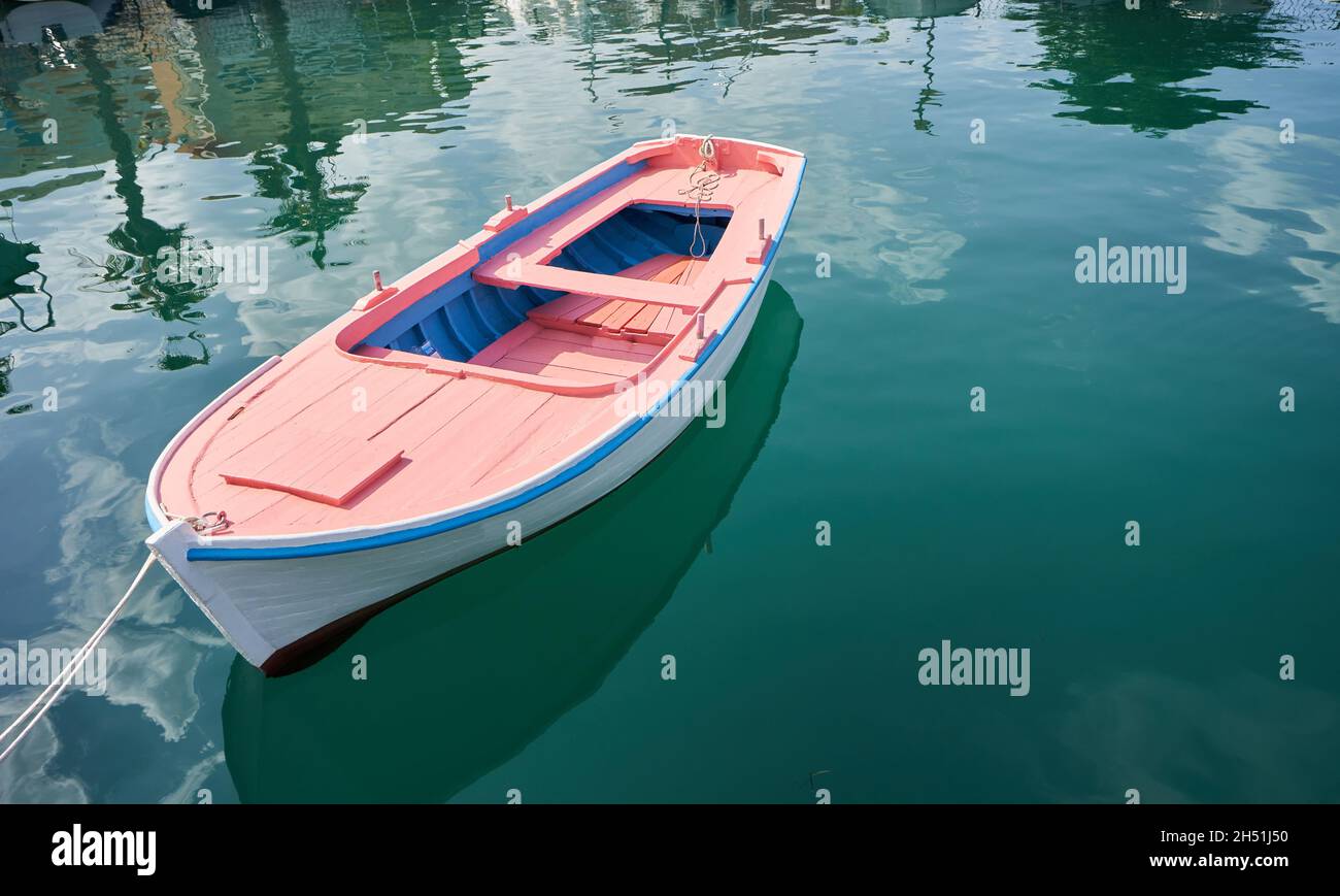 Cute pink wooden boat on the water at the dock Stock Photo - Alamy