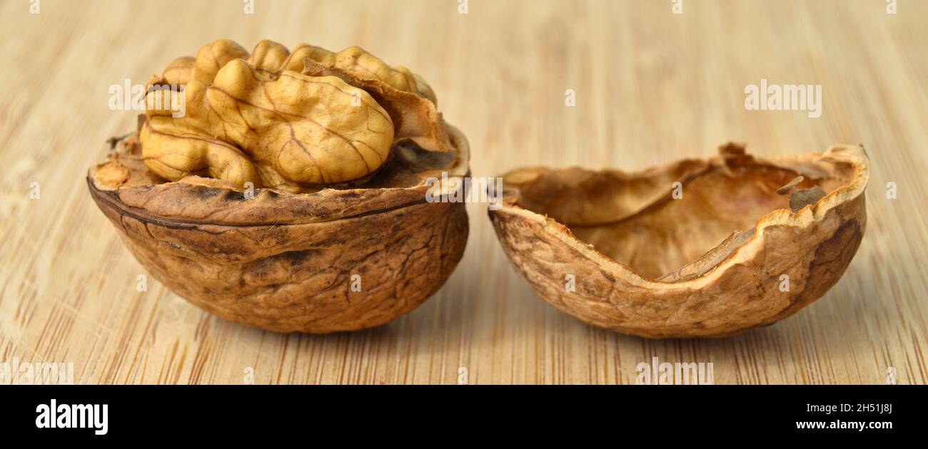 Healthy and nutritious beige brown walnut grains, bamboo on cutting ...