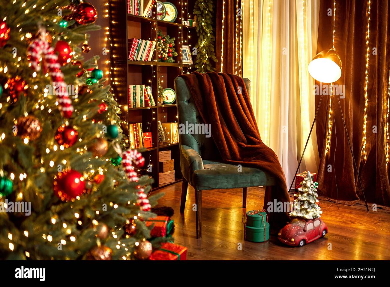 Stylish room interior with cozy armchair and beautiful Christmas tree ...