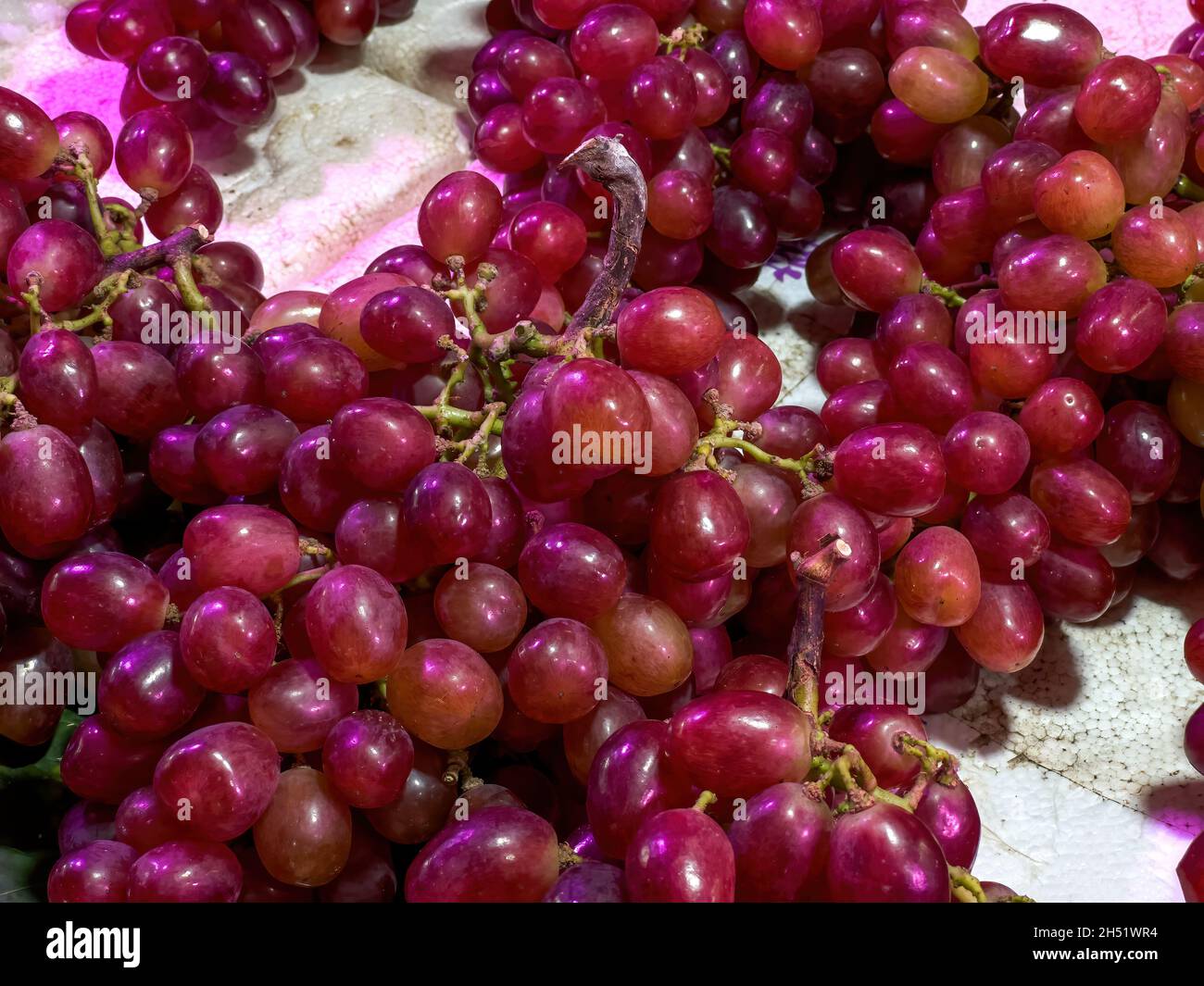 Close-up of a bunch of red grapes sold in a vegetable market stall ...