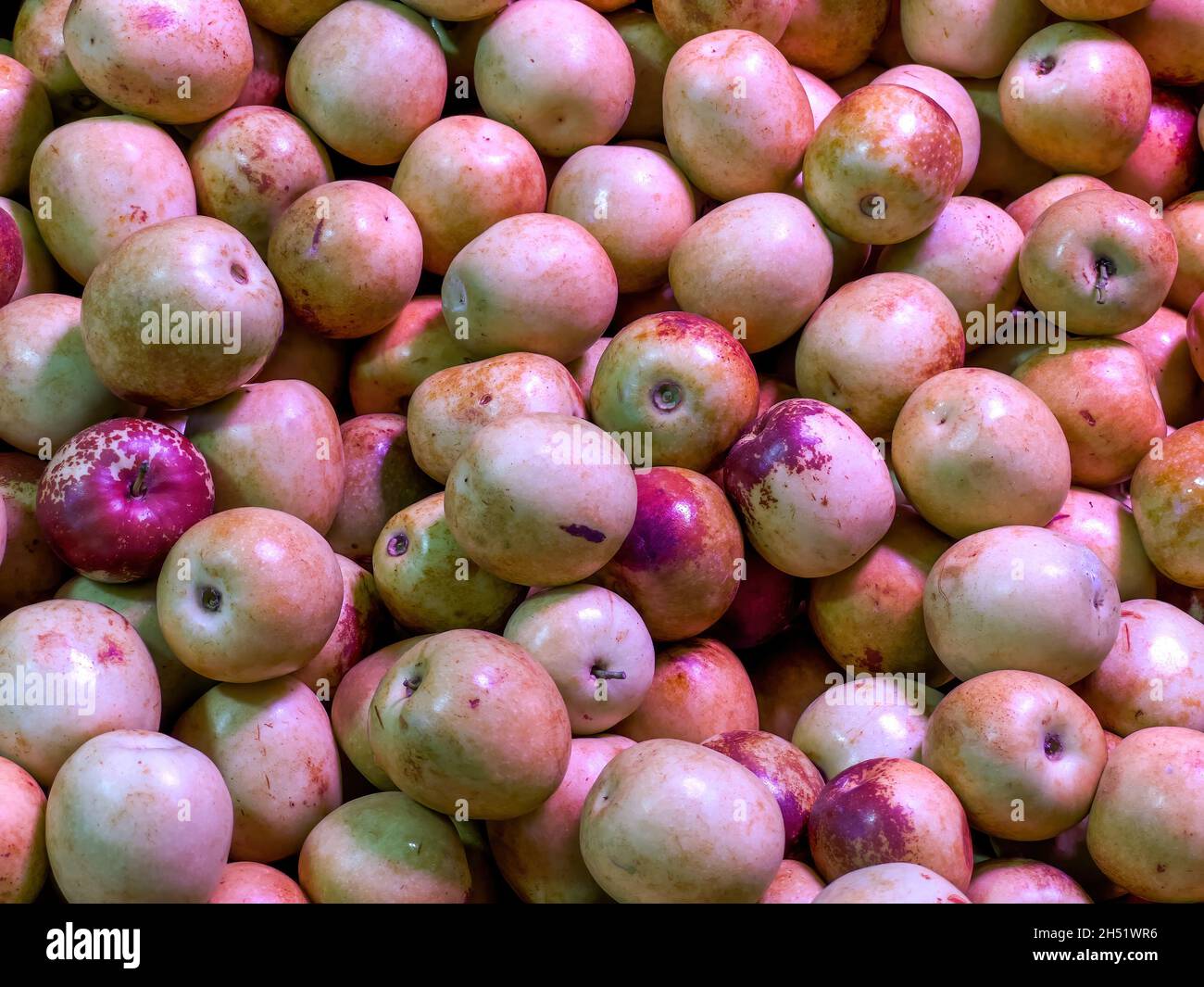 Close-up of a pile of big green dates sold in a vegetable market stall ...