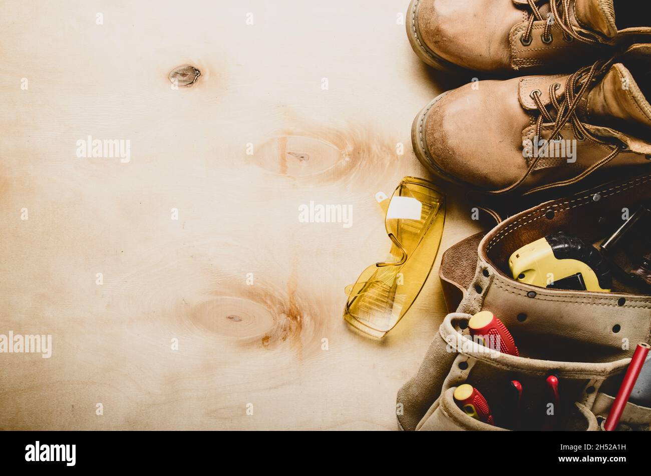 Construction concept background of toolbelt yellow boots goggles ant ...