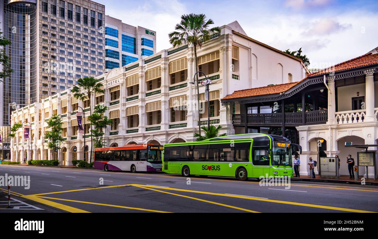 Buses stopped at bus stop outside Raffles Hotel picking up passengers ...