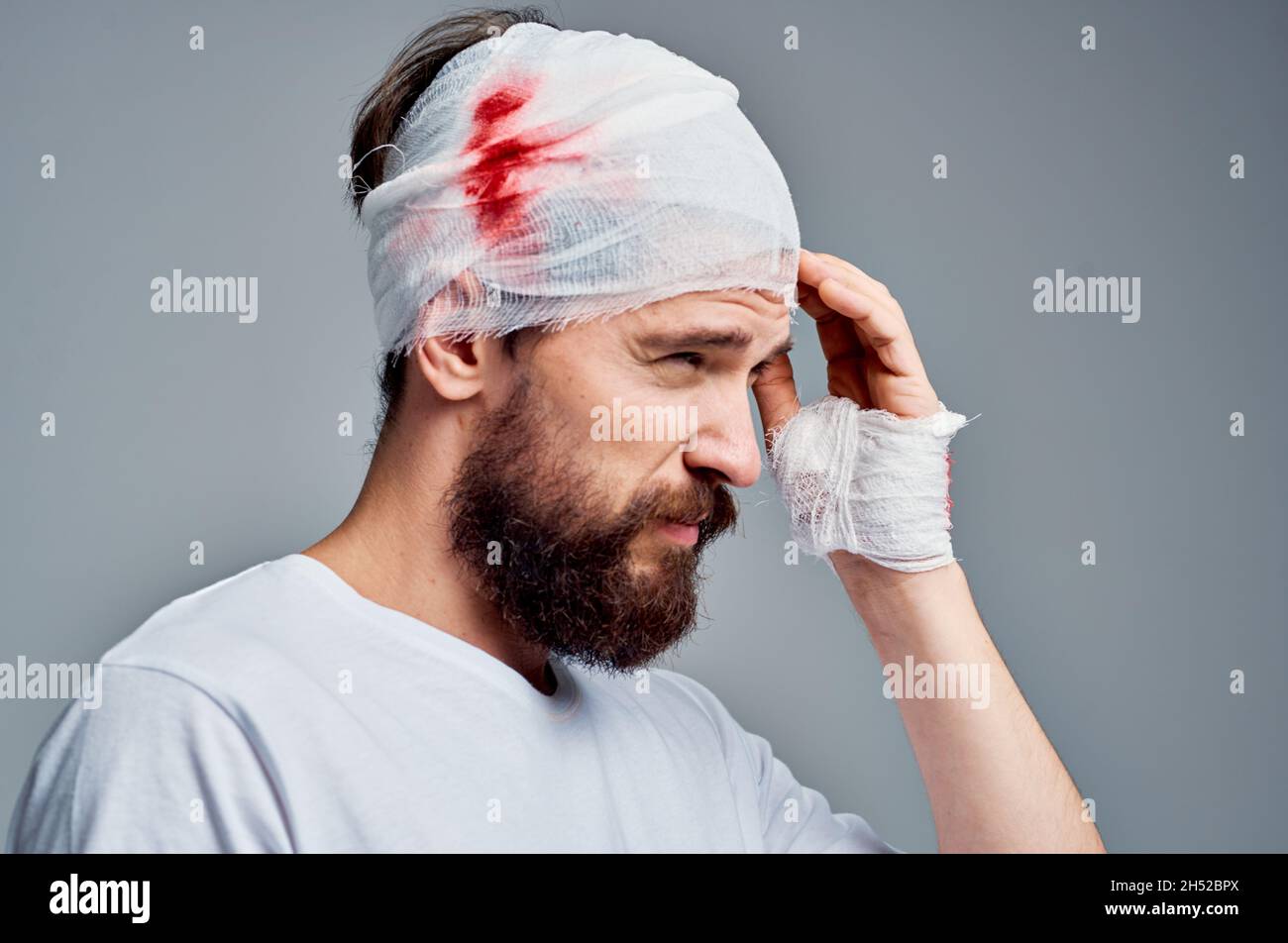 Man bandaged head and hand blood isolated background Stock Photo - Alamy