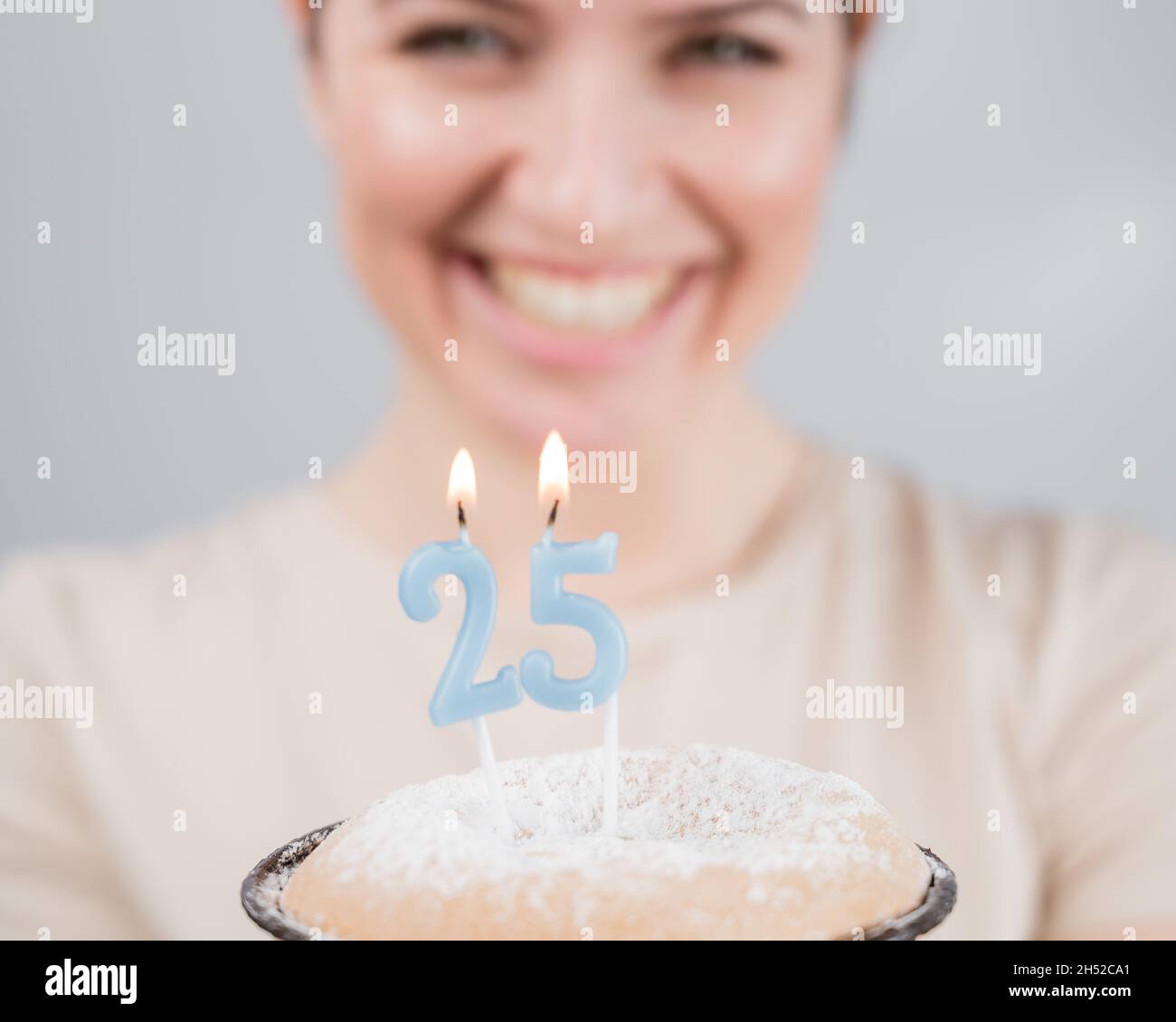The happy woman makes a wish and blows out the candles on the 25th ...